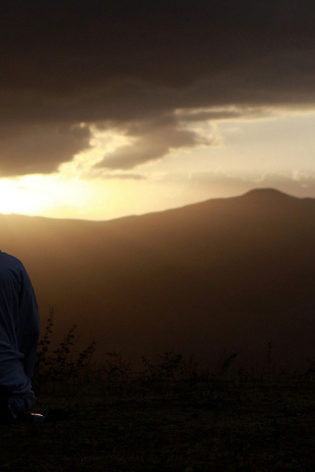 Man Praying In Shadow- WallpaperUse